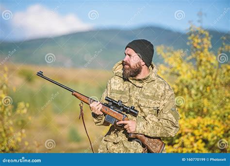 Bearded Hunter Man Holding Gun And Walking In Forest Hunting Without