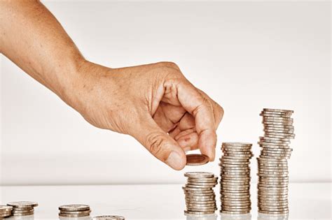 동전을 들고 남자의 손과 스택에 수집합니다 카피 스페이스를 통해 백색 배경에 대한 투자 성장 비즈니스 성공 및 비용 절감개념