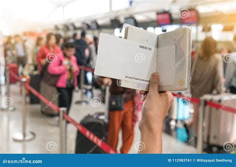 Close Up Of Young Woman Holding Passport And Blank Boarding Pass At Airport Counters Reception