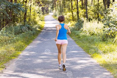 Sporty бегун молодой женщины бежать на дороге Стоковое Изображение