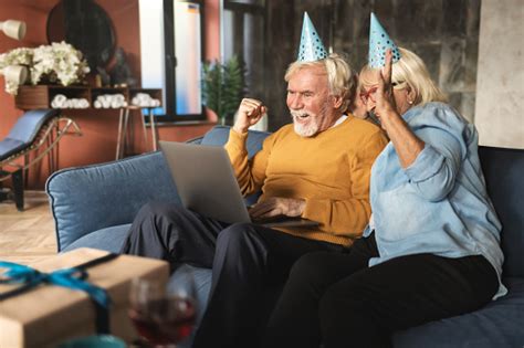 생일 또는 기념일 축하 화상 회의 휴일 인사말 개념에 대한 노트북에 화상 통화를 만드는 쾌활한 백인 수석 커플 2명에 대한 스톡