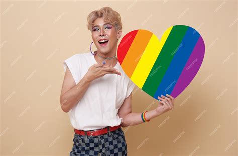 누드 색상 배경 위에 고립 된 무지개 심장을 보여주는 청소년 아시아 트랜스 젠더 Lgbt 프리미엄 사진