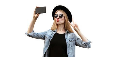 스마트 폰으로 셀카를 찍는 젊은 여성이 입술을 불고 흰색 배경에 고립 된 검은 둥근 모자를 쓰고 키스를하는 초상화 20 29세에 대한 스톡 사진 및 기타 이미지 Istock