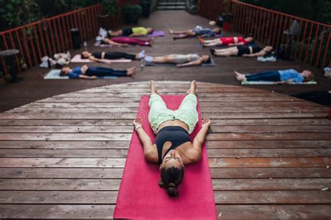 Group Of Young Sporty People Practicing Yoga Lesson With Instructor