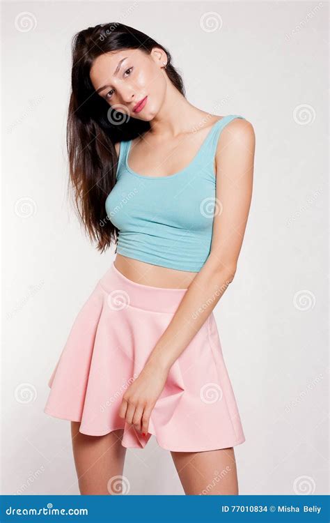 A Menina Glamoroso Sexy Na Saia Cor De Rosa E A Turquesa Cobrem Foto
