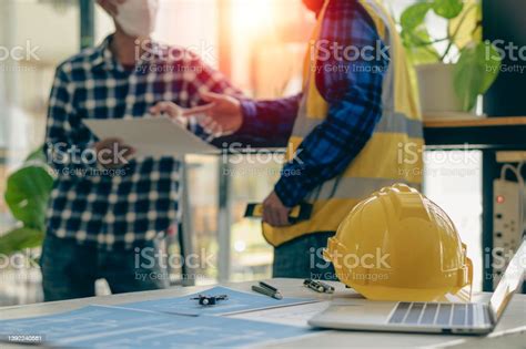 청사진 및 계획 작업 건물 엔지니어가 건물 건설에서 주택 설계를 계산하고 초안을 작성하는 데 전념하는 작업장에서 엔지니어링 객체를 가진 전문 건축가 2명에 대한 스톡 사진