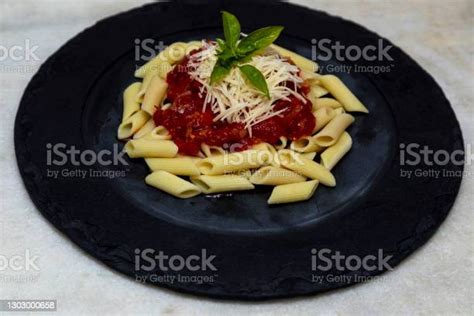 블랙 플레이트에 붉은 소스와 파마산 치즈를 곁들인 펜네 파스타 돌 또는 콘크리트 배경 건강한 생활방식에 대한 스톡 사진 및 기타 이미지 건강한 생활방식 건강한 식생활
