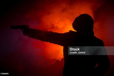 소총 어두운 톤된 안개 배경 또는 검은 발라 클 라바 손에 들고 총 입고 위험한 산적에 공격을 준비와 남자의 실루엣 테러 무기 테마 장식으로 촬영 Ak 47 소총에 대한