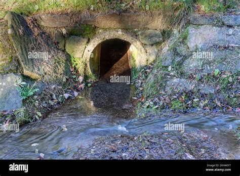 Clean Transparent Water Flowing From Concrete Drainage Pipe Into A