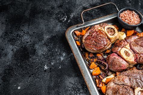 강철 쟁반에 야채 소스를 곁들인 이탈리안 찐 송아지 정강이 스테이크 Ossocbuco 검정 배경입니다 평면도 복사 공간 갈색에 대한 스톡 사진 및 기타 이미지 Istock