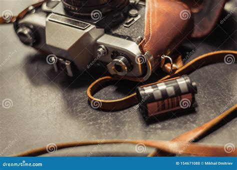 Vintage Camera In A Brown Leather Case Lies On A Dark Table Near The