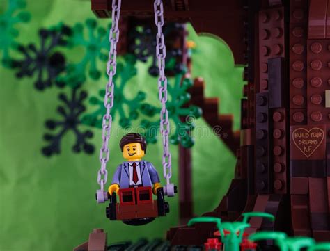 A Lego Businessman Minifigure On A Swing That Is Hanging On A Tree