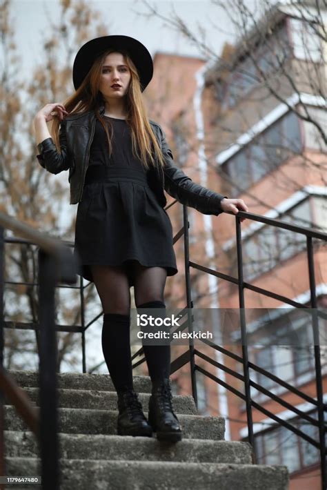 한 소녀가 전화기를 들고 가죽 조끼를 입고 도시 거리를 걷고 있다 모자와 어두운 메이크업 외부젊은 아름다운 소녀 거리에서 고딕 양식의 소녀 가을에 대한 스톡 사진 및 기타