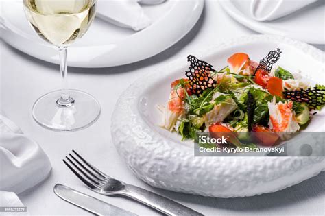 게 완두콩 콩나물 토마토 양상추 레이스 칩 파슬리 치즈를 와인과 칼 붙이 한 잔과 함께 밝은 배경의 접시에 담은 샐러드 0명에 대한 스톡 사진 및 기타 이미지 Istock