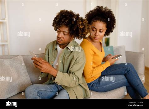 Black Wife Spying Reading Husbands Messages Peeking At Phone Indoors