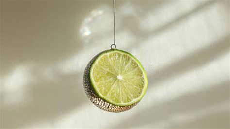 Hanging Lime Slice Disco Ball Casting Shadows Minimalistic Aesthetic