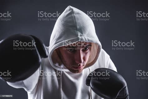 권투 장갑을 낀 청년과 스튜디오의 어두운 배경에 흰색 스웨트셔츠를 입은 청년 승리와 전투의 개념 결심에 대한 스톡 사진 및 기타