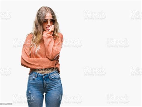 아름 다운 젊은 금발 여자는 스트레스와 입 물고 손톱에 손으로 긴장 찾고 고립 된 배경 위에 선글라스를 입고 불안 문제 감정에