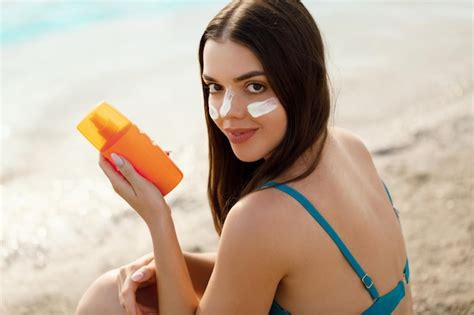 Premium Photo Beautiful Woman Applying Cream Sunscreen On A Tanned