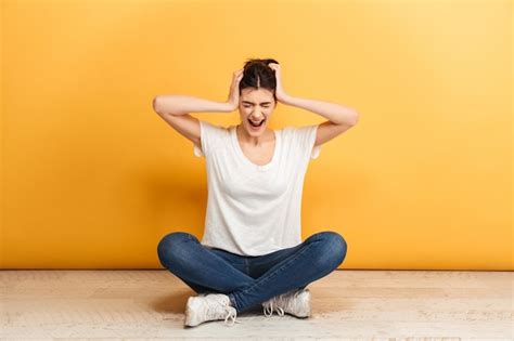 Premium Photo Portrait Of A Annoyed Young Woman Sitting With Legs Crossed
