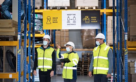 헬멧과 안면 마스크를 쓴 작업자 그룹이 창고에서 실내에서 일하고 있으며 코로나바이러스 개념입니다 사진 Unsplash의 슬로바키아 이미지