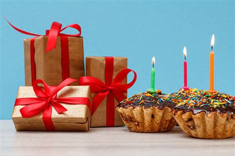 선물 상자와 파란색 배경에 불타는 축제 촛불이있는 생일 컵 케이크 기념일에 대한 스톡 사진 및 기타 이미지 기념일 머핀