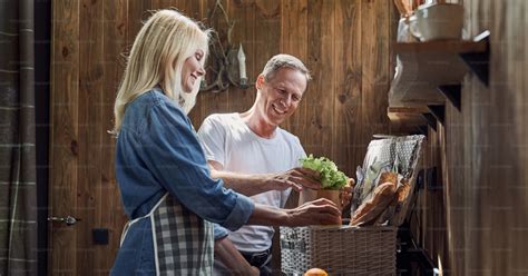 즐거운 사랑의 남자와 여자는 부엌에서 고리 버들 바구니에 과일과 채소를 포장하고 있습니다 사진 Unsplash의 토마토 이미지