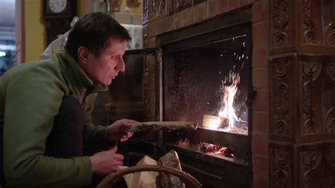 A Man Putting Firewood Into Fireplace Keeps Stock Footage Sbv 348758256