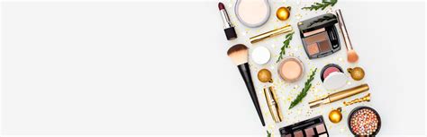 메이크업 마스카라 파운데이션 크림 립스틱 아이섀도우 홍당무 볼과 새해 장식 골드 크리스마스 볼 색종이 별 전나무 가지 밝은 배경에 플랫 누워 상단 뷰 화장품 휴일 크리스마스