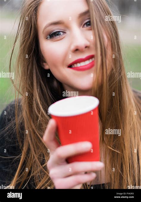 Portrait Of Young Beautiful Stylish Girl Drinking Coffee In The Park