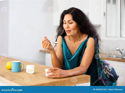 Portrait Of Woman Eating Yoghurt At Home Stock Image Image Of Leaning Asian