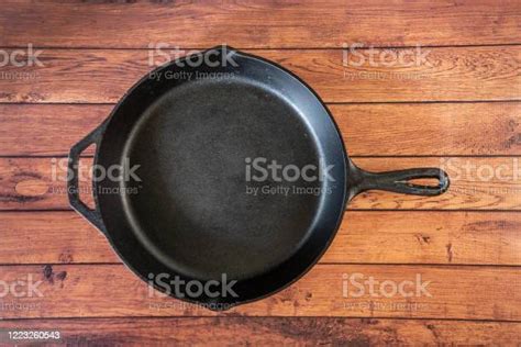 나무 표면에 전통적인 무거운 의무 주철 프라이팬 복사 공간 고립 된 상단보기 검은 요리 기구 캠프 파이어 조리기구 및 주방 용품