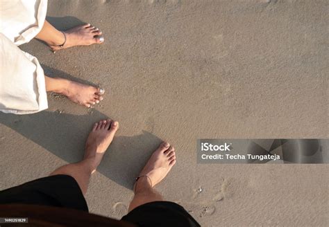 맨발로 연인 커플 여자와 남자가 저녁 일몰에 따뜻한 햇살을 받으며 깨끗한 모래 해변에 서 있다 허니문 여름 여행 레저 목적지 휴가 컨셉 발에 대한 스톡 사진 및 기타 이미지
