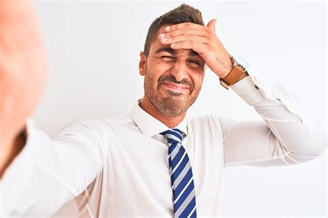 젊은 잘생긴 사업가는 머리에 손으로 스트레스 고립 된 배경을 통해 스마트 폰을 사용하여 셀카를 복용 수치와 깜짝 얼굴 분노와