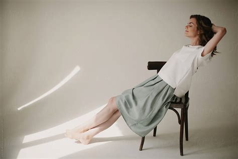 Young Smiling Woman Relaxing On Chair With Closed Eyes By Stocksy