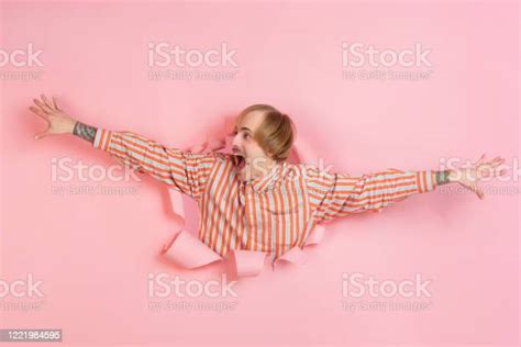 쾌활한 젊은 남자 찢어진 산호 종이 구멍 배경 감정과 표현에서 포즈 감정에 대한 스톡 사진 및 기타 이미지 감정 곱슬 머리