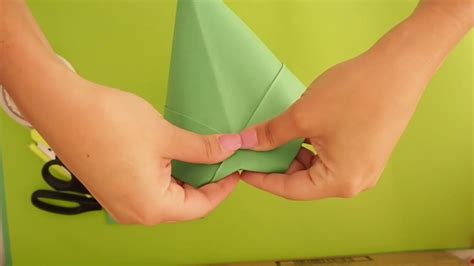 Someone Is Making A Paper Origami Cone With Scissors And Glue On The Side