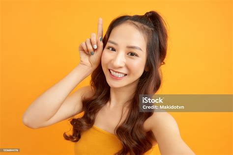 고함을 지르는 배경에 고립 된 스마트 폰에서 셀카 사진을 만드는 웃는 귀여운 여성의 초상화 25 29세에 대한 스톡 사진 및