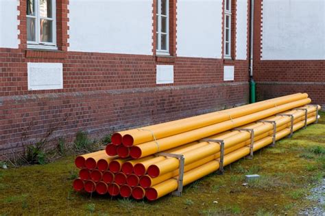 주황색 노란색 Pvc 도관 파이프의 도시 스택에 있는 건설 현장 프리미엄 사진