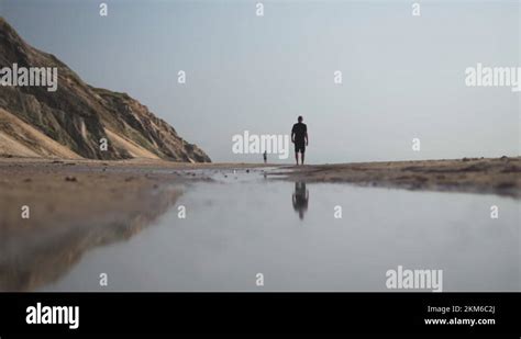 Man Walking Barefoot Through Seawater On Beach Stock Video Footage Alamy
