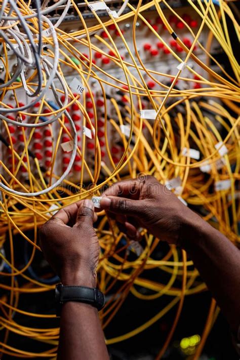 Male Hands Connecting Cables And Wires In Server Room While Setting Up Network Stock Photo