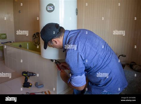 Plumber In The Bathroom At Home While Repairing A Water Heater