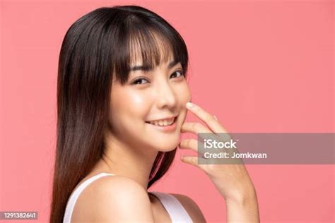 핑크 배경 뷰티 코스메틱 스파 트리트먼트 컨셉으로 깨끗하고 신선한 피부 행복과 쾌활한 모습으로 부드러운 뺨을 만지는 젊은
