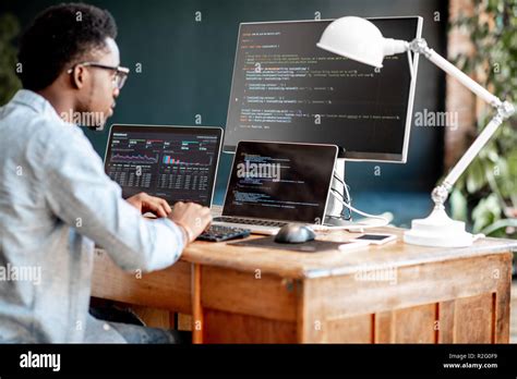Young African Male Programmer Writing Program Code Sitting At The