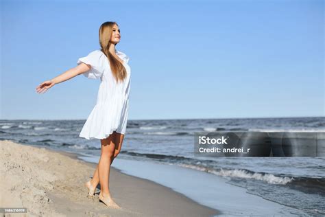행복한 미소를 짓는 아름다운 여자가 두 팔을 벌려 바다 해변을 걷고 있다 18 19세에 대한 스톡 사진 및 기타 이미지 18 19세 건강한 생활방식 걷기 Istock
