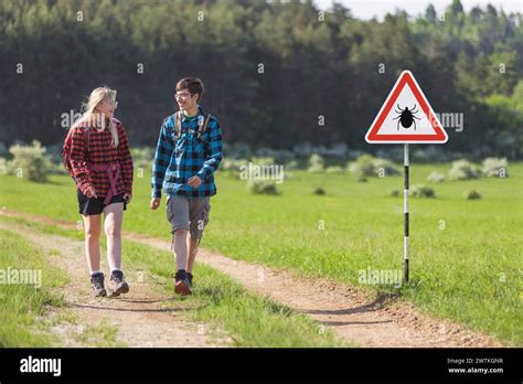 Hikers Walking Past Tick Infected Area With Danger Sign Risk Of Tick