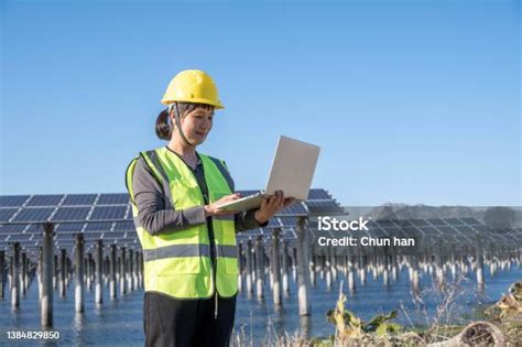 아시아 여성 엔지니어가 바다 의 태양광 태양광 발전소에서 노트북과 함께 일합니다 직업에 대한 스톡 사진 및 기타 이미지 직업 태양전지판 인물 사진 Istock