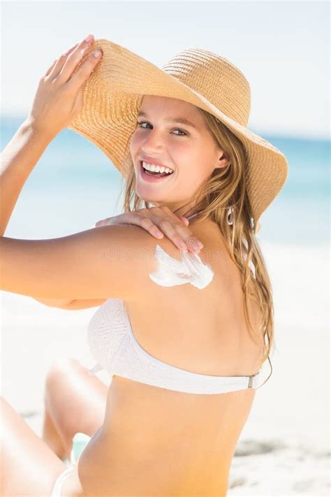 Pretty Blonde Woman Spreading Sun Tan Lotion On Her Arms Stock Image