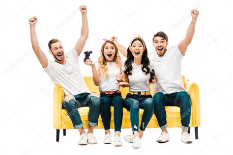 emocionados jóvenes amigos sentados en el sofá y jugando con joysticks