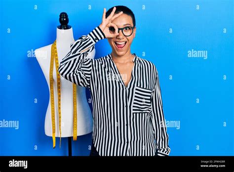 Beautiful Hispanic Woman With Short Hair Standing By Manikin Smiling